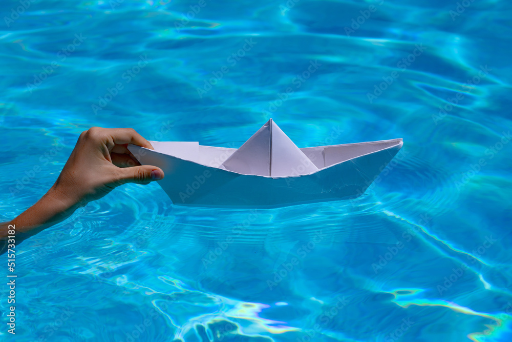 Hand holding paper boat on the sea background. Paper boat in hands on ...