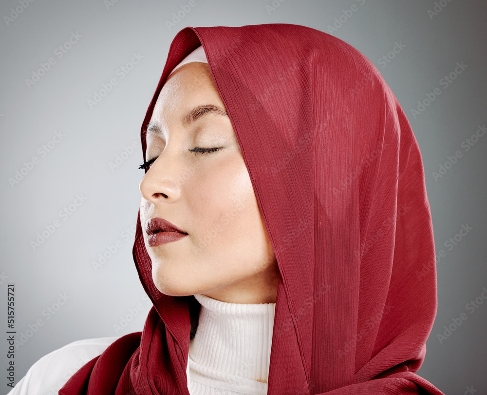 Stylish young muslim woman in a red hijab with her eyes closed on a ...