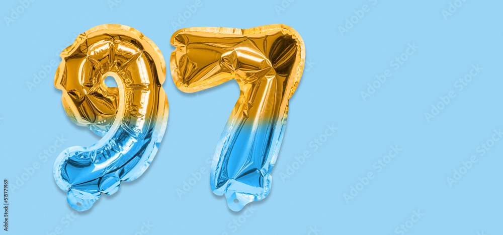 Rainbow foil balloon number, digit ninety seven on a blue background ...