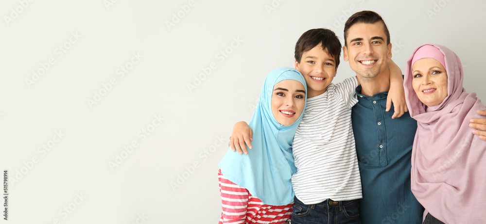 Portrait of happy Muslim family on light background with space for text ...