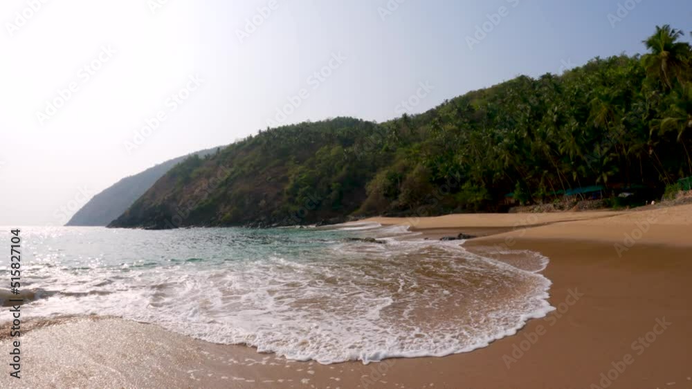4K wide angle shot of tropical Kakolem beach besides the palm trees at ...