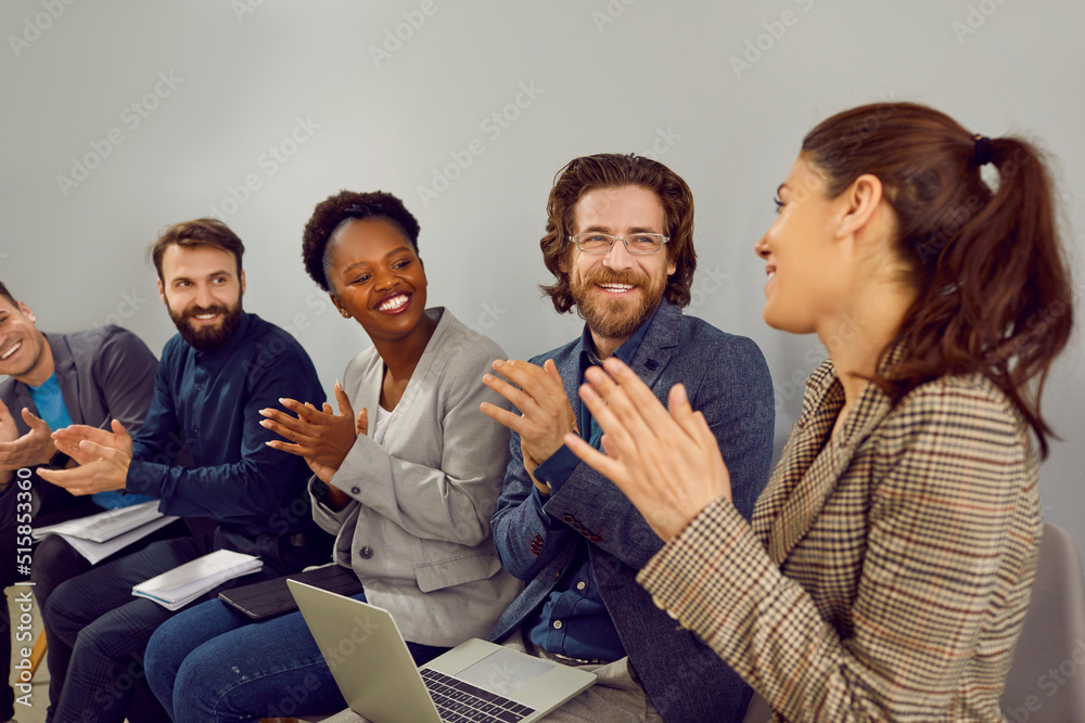 Happy business team applauding young woman after creative presentation ...