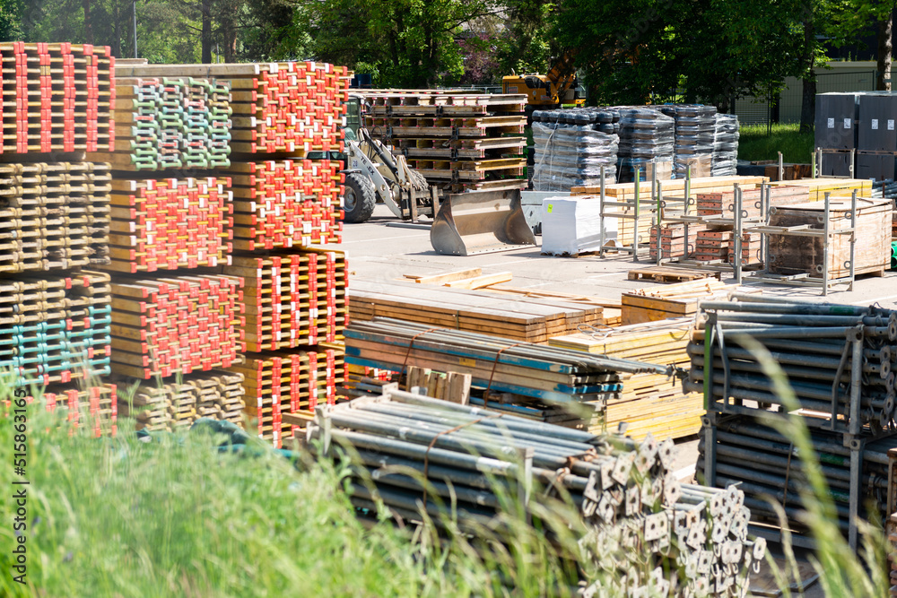 various different stacks of pallets at building site construction place ...