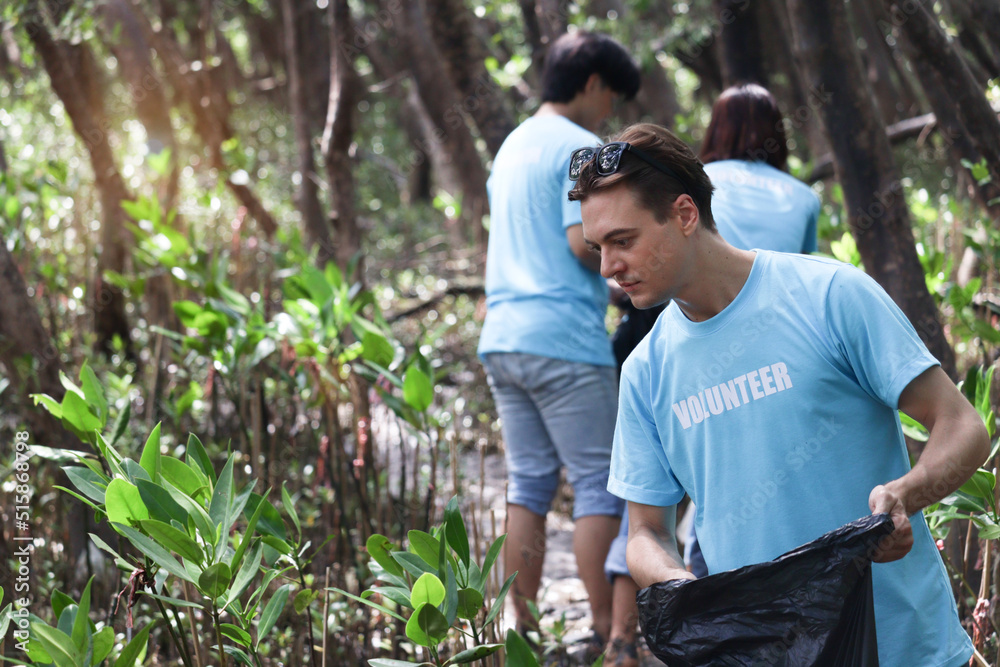 Group of volunteers in blue t-shirt hold garbage bag, ecology people ...