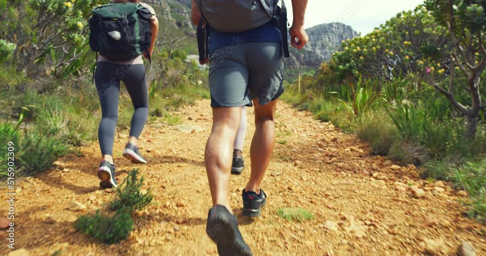 Hikers running up a trail on a mountain with backpacks. Diverse group ...