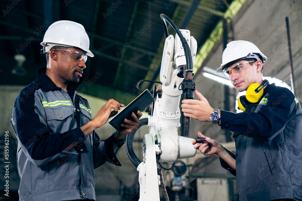 Factory workers working with adept robotic arm in a workshop . Industry ...