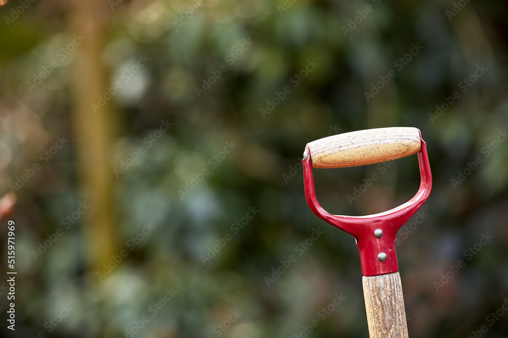 Closeup of wooden shovel handle in a garden or field with copyspace ...