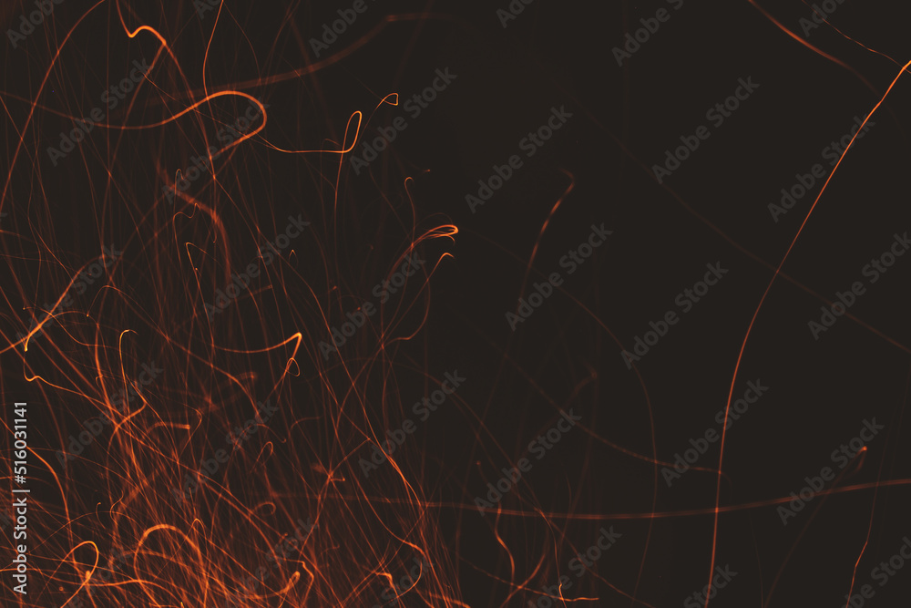 Burning red hot sparks fly from large fire in the night sky. Beautiful ...