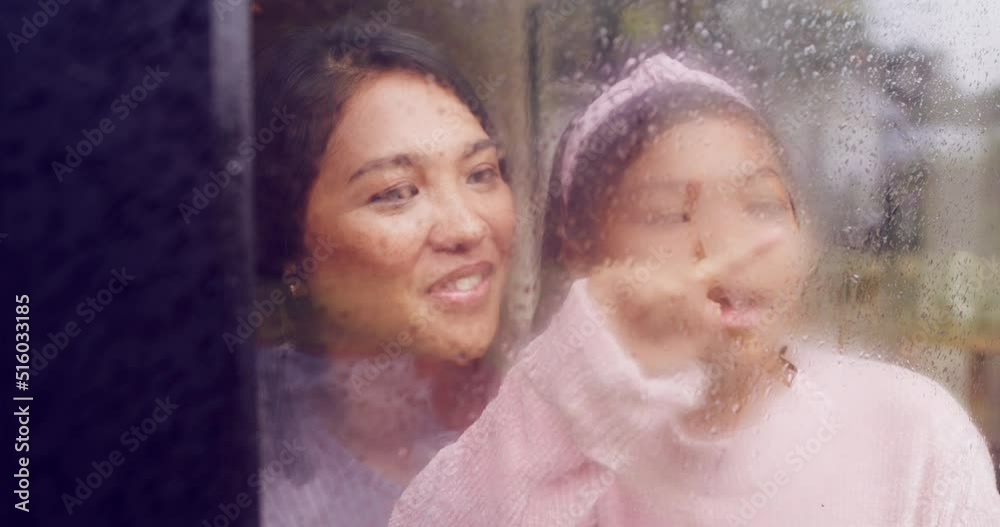 Child bonding, blowing and drawing a heart on foggy window with single ...