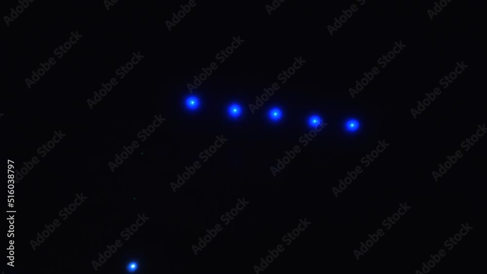 Bright colored lights move in rows in the night sky with theatrical ...