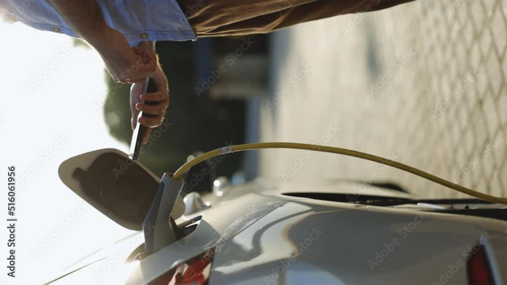 Vertical video of man unplugging electric car cable. Guy stopping ...