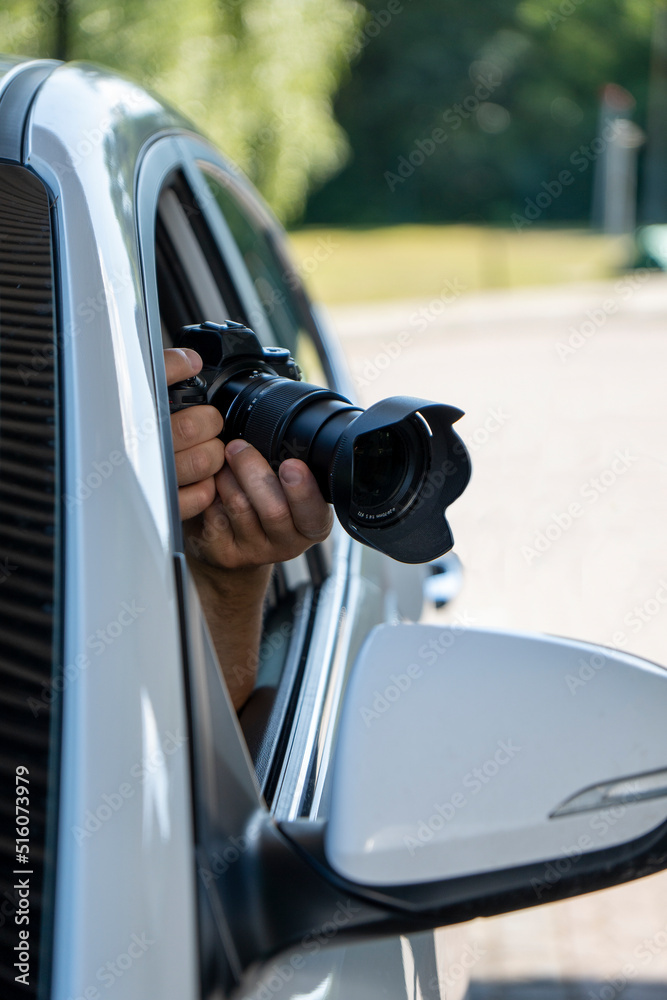 A paparazzi sits in his car and takes pictures of a famous person. Spy ...