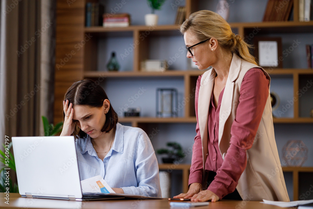 Angry female boss scolding scared office worker. Demanding manager ...