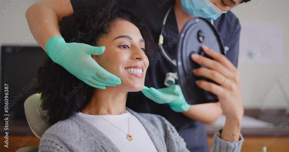 Dentist showing female patient mirror to check her teeth after ...