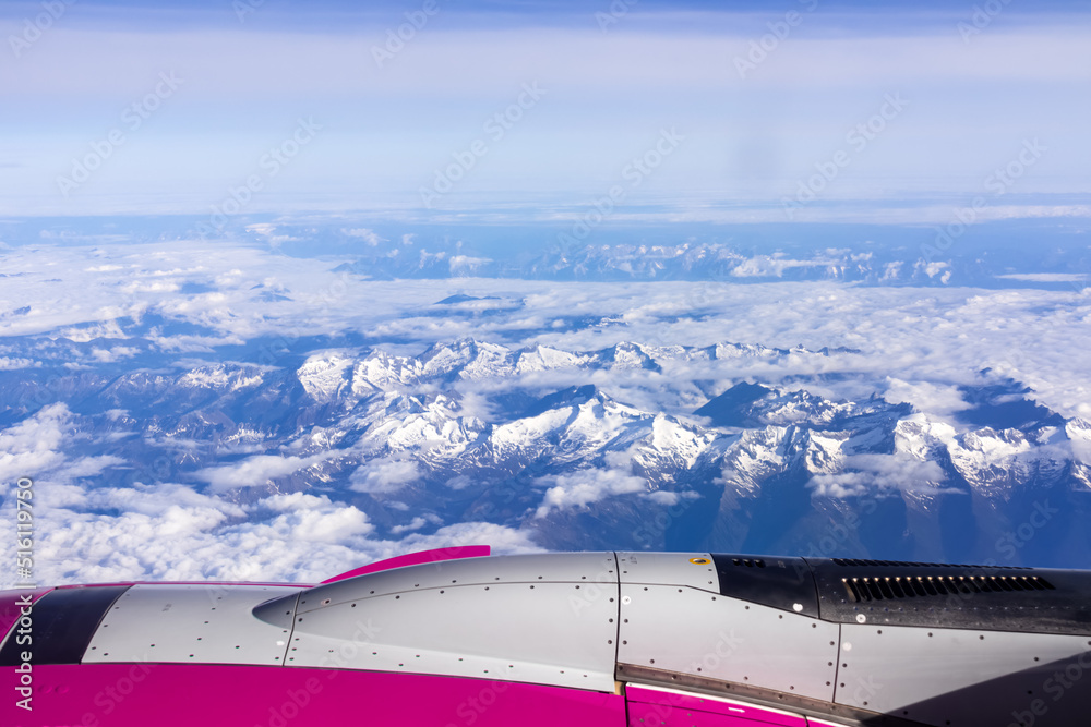 Window view from an airplane on snow capped mountain ranges of the ...