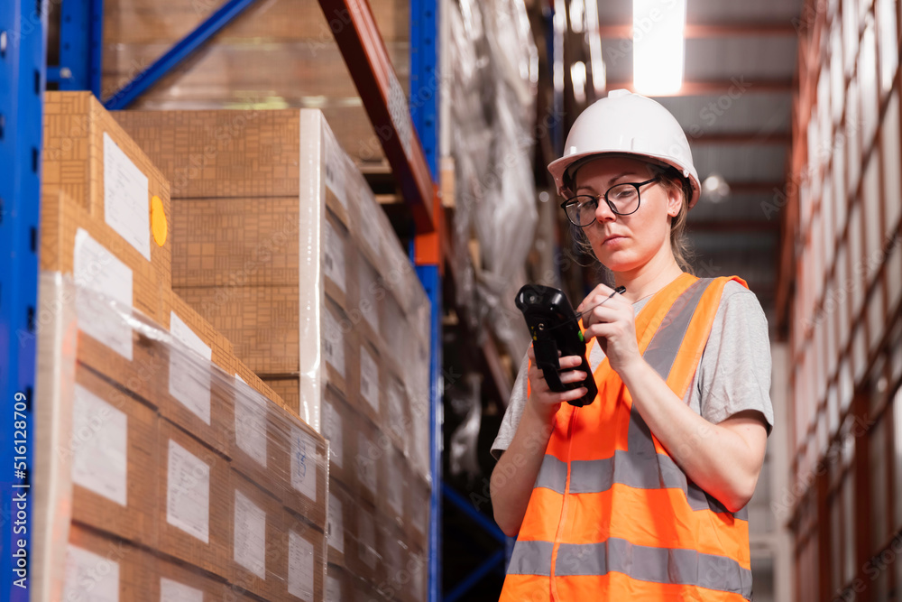 Female workers in safety helmet using scanner checking inventory stock ...