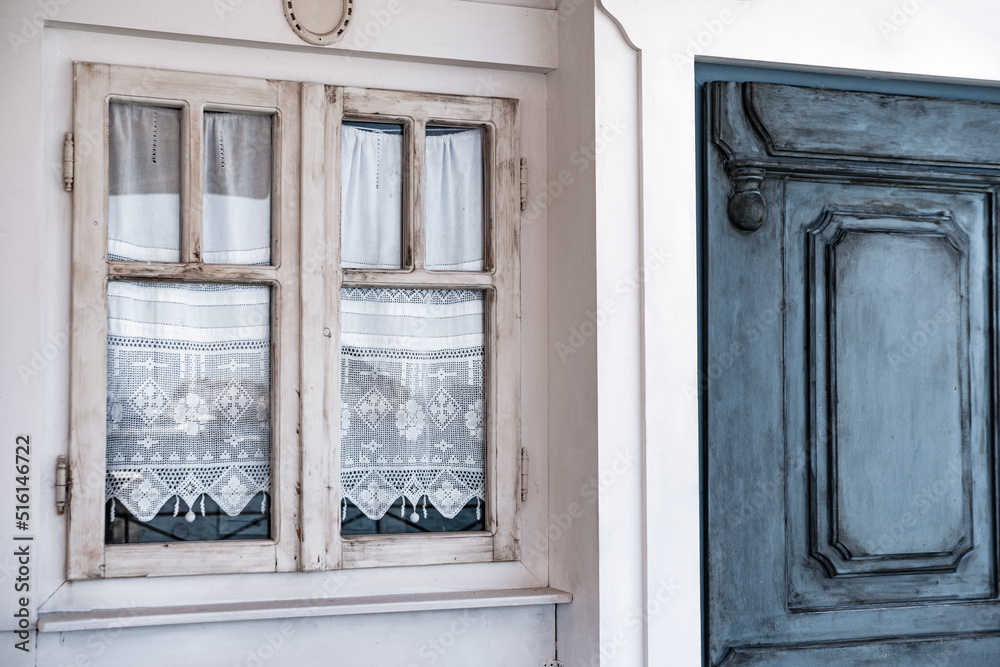 tiny old style vintage house facade with a wooden door and creamy color ...