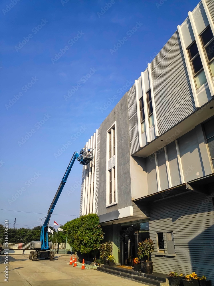 Manlift crane with platform lifting to the roof top of a building Stock ...