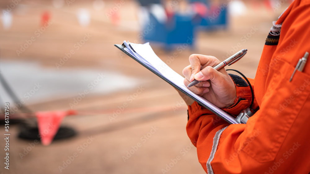 Action of safety officer is writing and check on checklist document ...