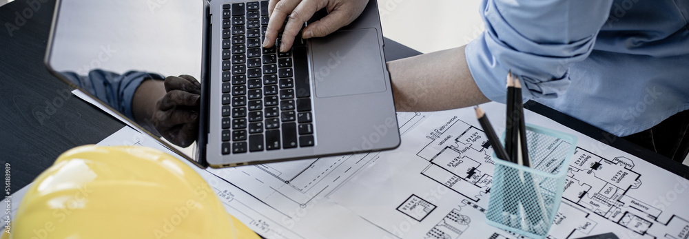 Foto de Young man with a laptop plotting a system of building ...