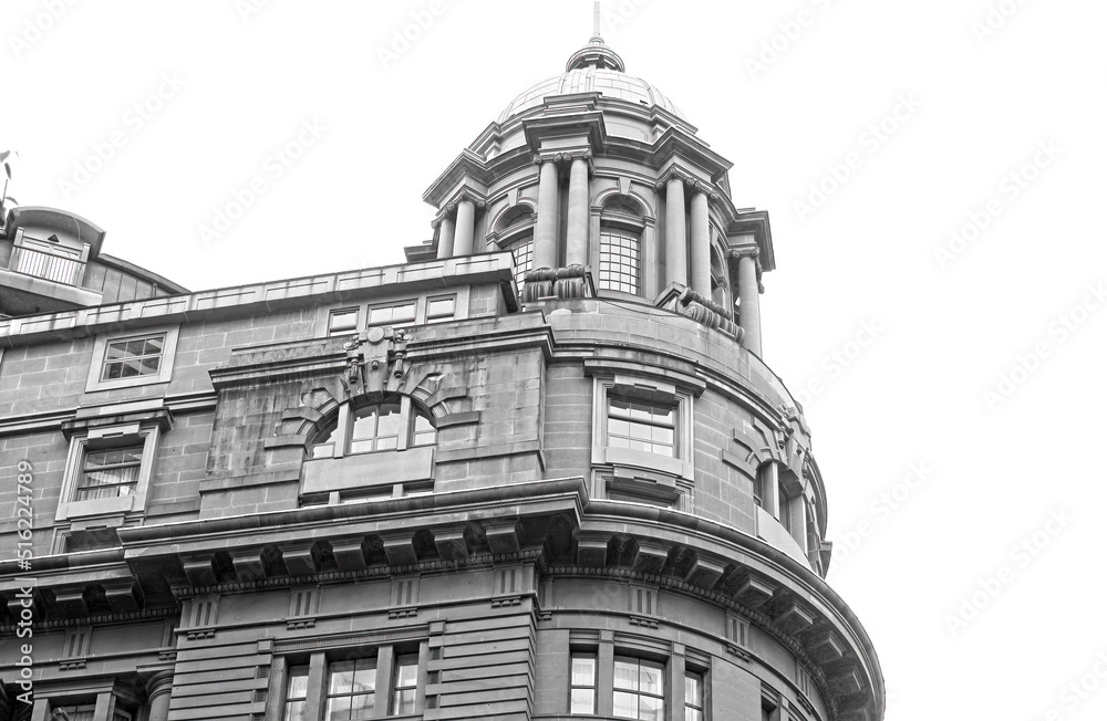 The top front corner of an old rounded sandstone building. Domed roof ...