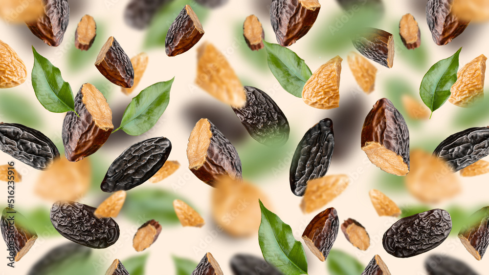 Tonka beans and green leaves float in the air. Flying Dipteryx odorata ...