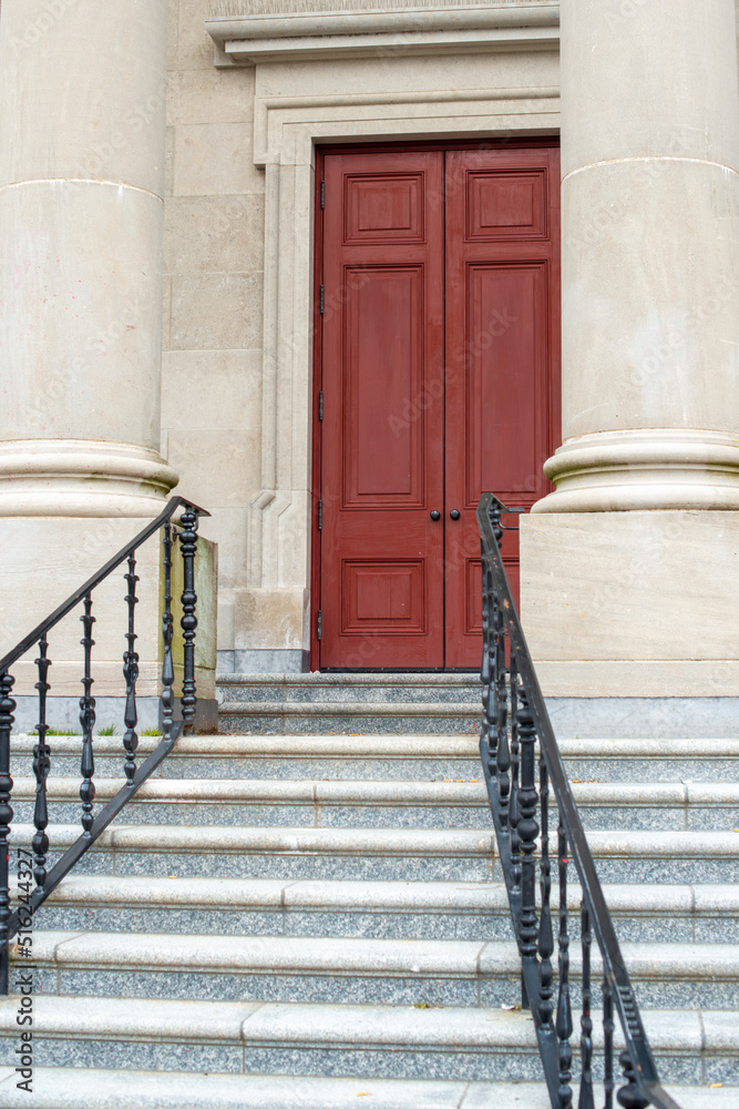 An upward view of a vintage justice courthouse with steps leading to a ...