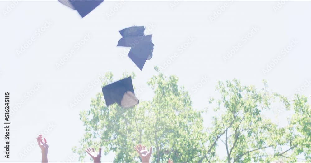 Happy students throwing hats into the air on graduation day. Excited ...