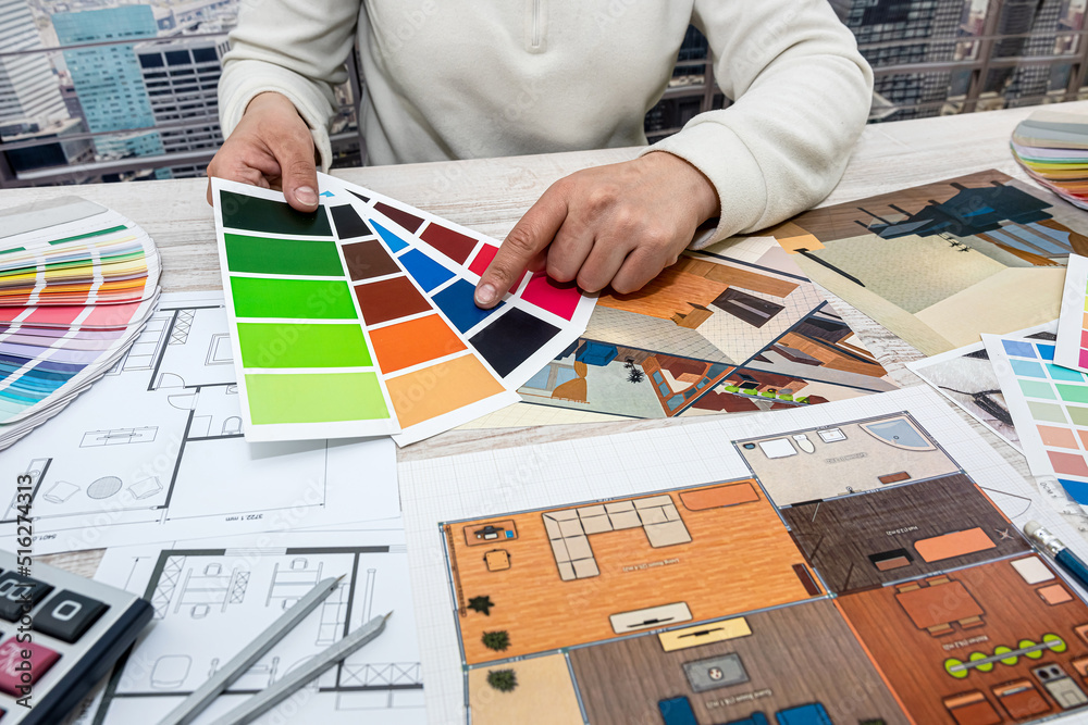 male in the office selects a palette of colors for drawings of the ...