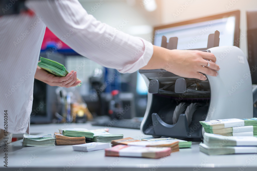 Large amounts of money in the bank. Bank employees sorting and counting ...