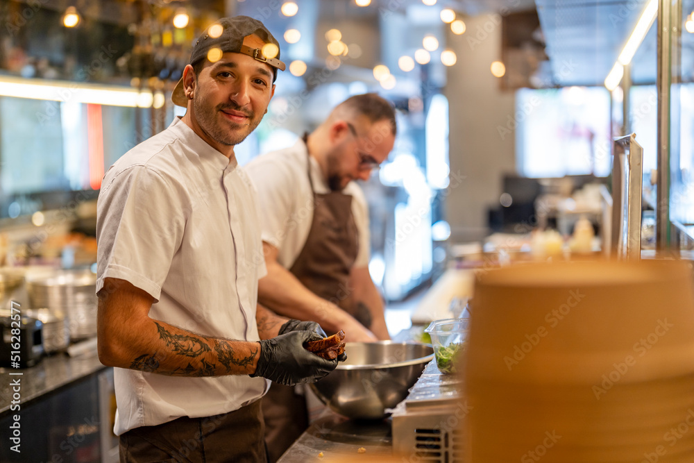 Smiling chef preparing with food in kitchen of restaurant Stock Photo ...
