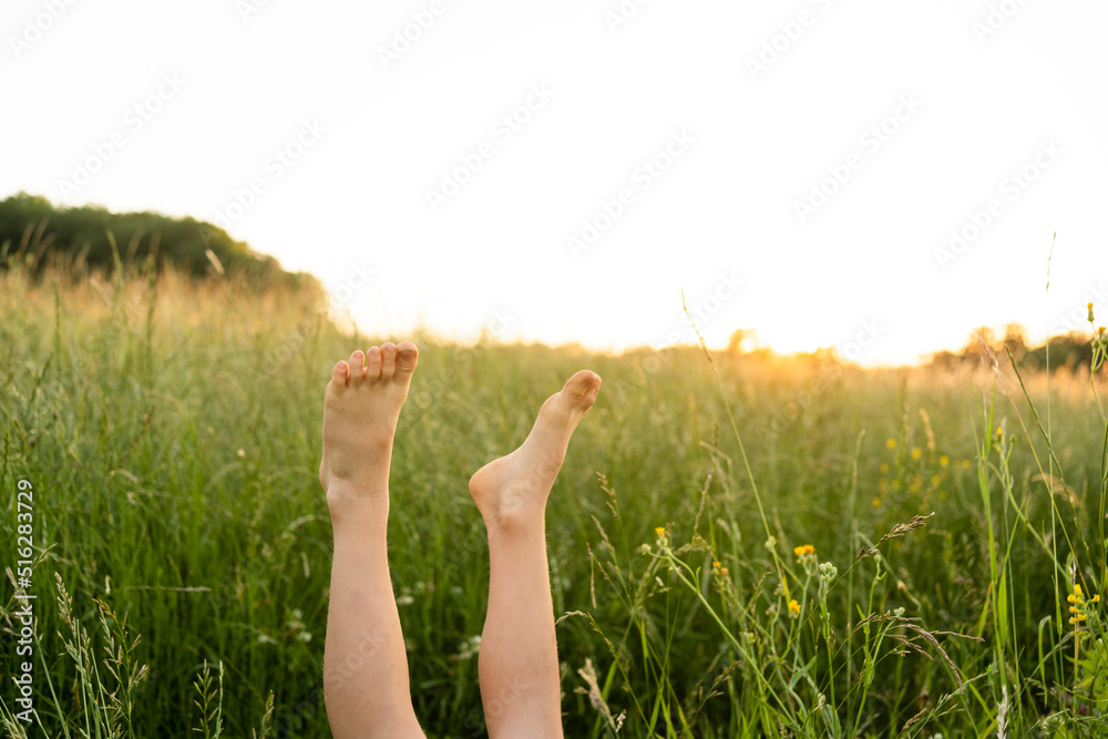 Girl with feet up in field Stock Photo | Adobe Stock