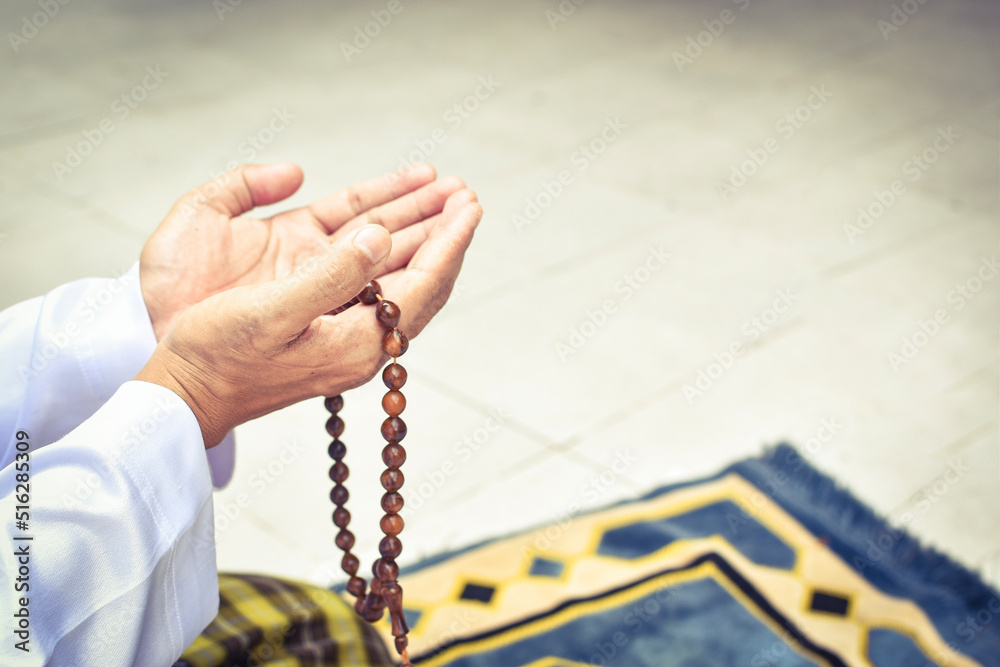 Muslim man in white session lift two hand for praying and wearing bead ...