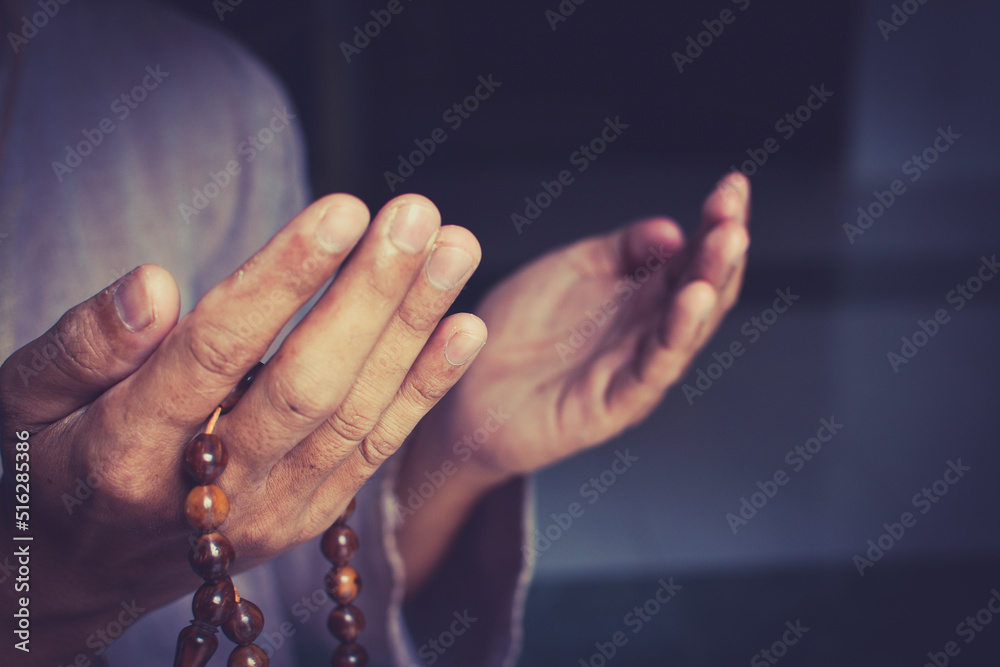 Muslim man in brown session lift two hand for praying and wearing bead ...