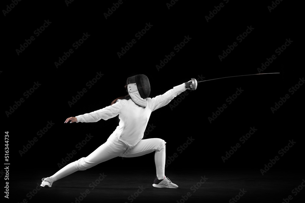 Energetic female fencer in white fencing costume and mask in action ...