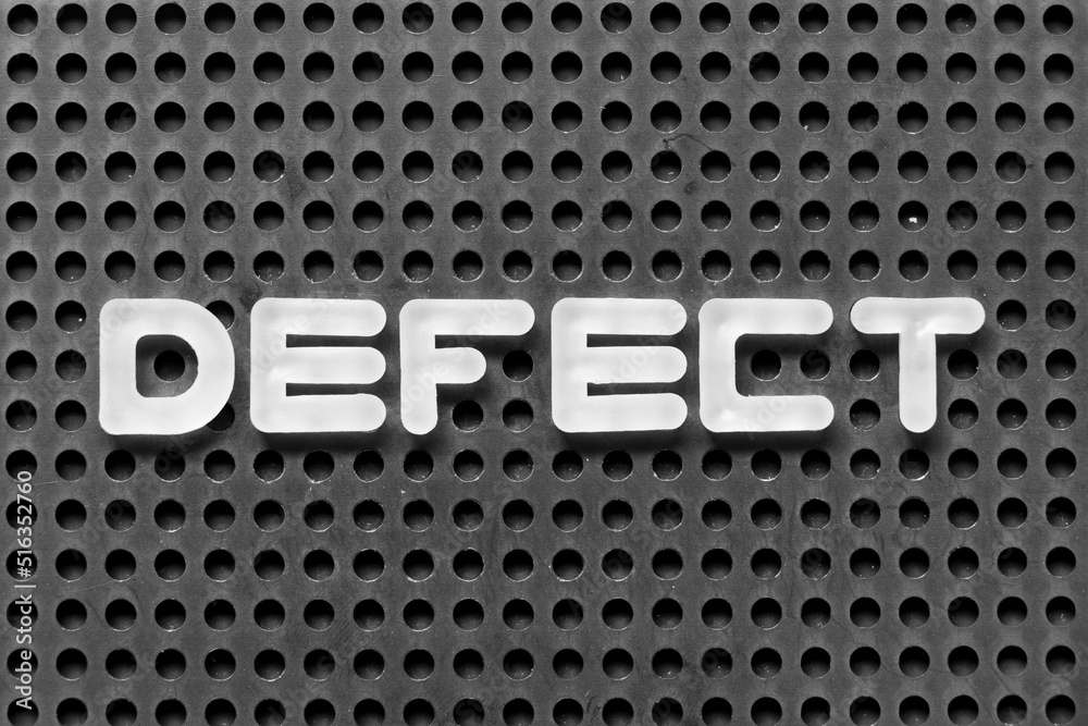 White alphabet letter in word defect on black pegboard background ...