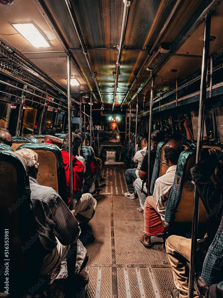 Vertical shot of people sitting on both sides of the aisle of a public ...