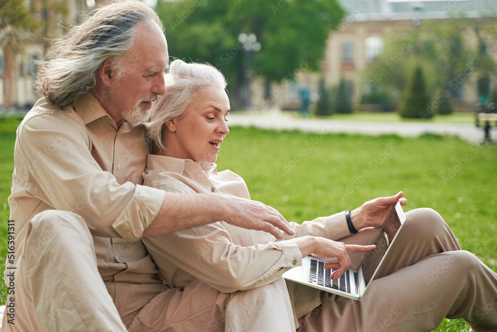 Pleased senior woman pointing at screen of laptop Stock Photo | Adobe Stock
