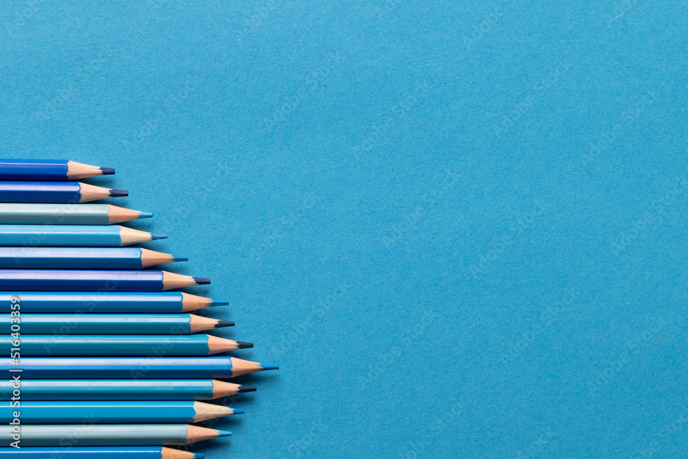 Image of row of different shades of blue crayons on blue background ...