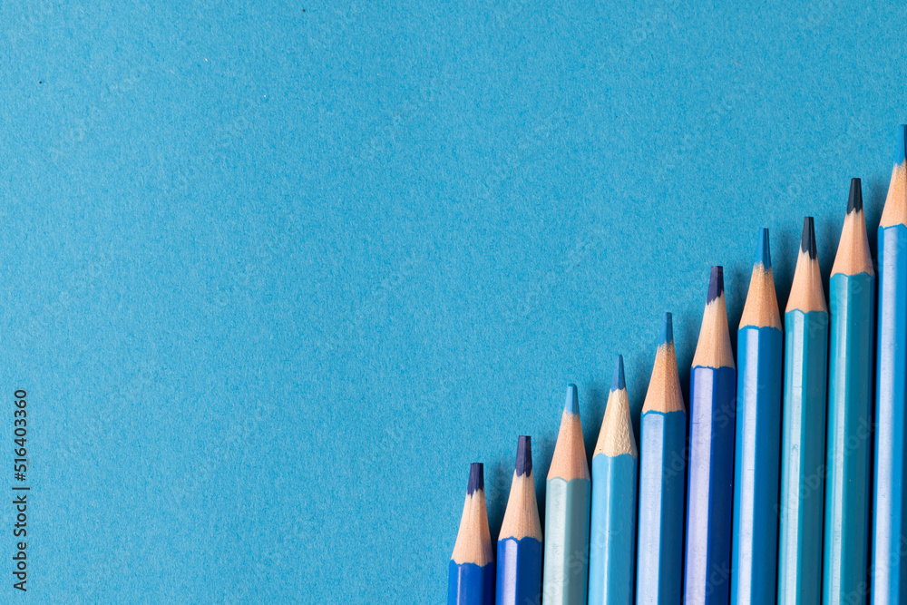 Image of row of different shades of blue crayons on blue background ...