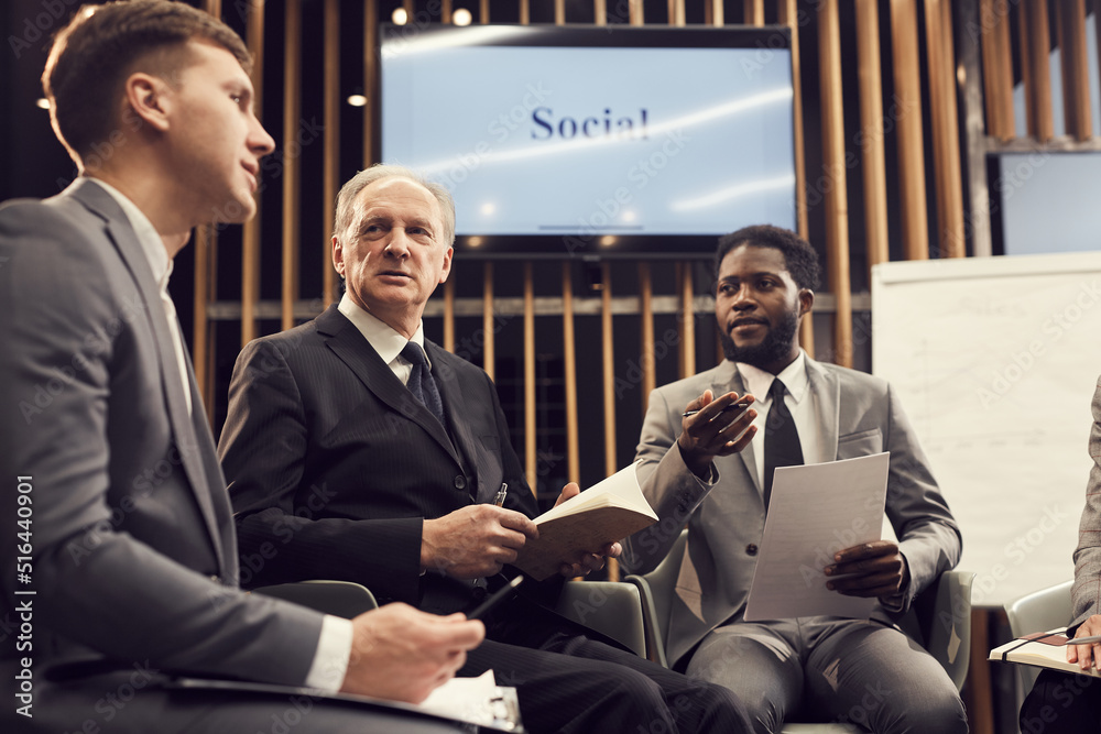 Thoughtful multi-ethnic businessmen in suits sitting in circle in ...