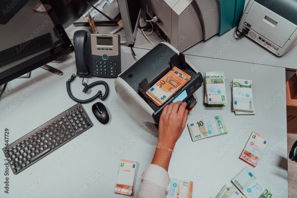Bank employees using money counting machine while sorting and counting ...