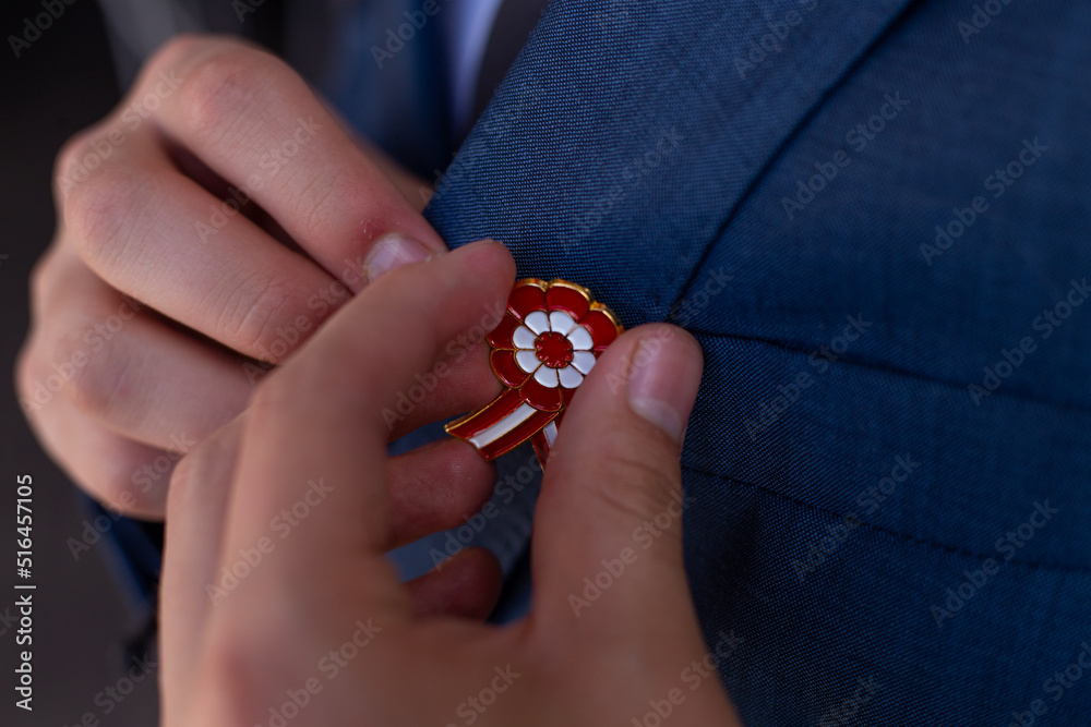 Fototapeta Manos colocando una escarapela de Perú en un traje. Concepto ...