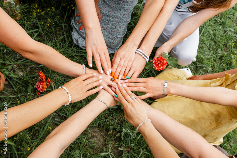 Female models joining hands in a circle. Group of people stacking hands ...