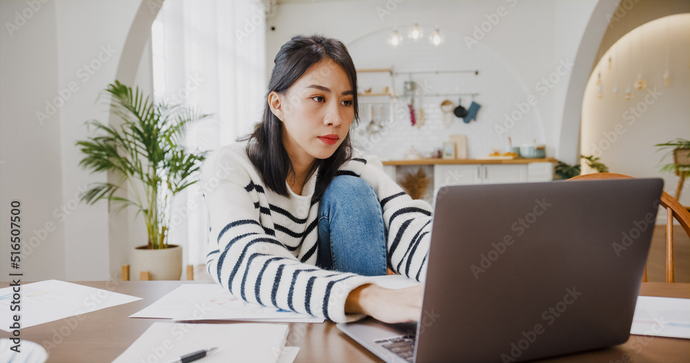 Young asia lady freelance focus on presentation work in laptop for ...