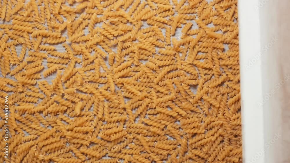 Shaking conveyor belt moves on just made dry pasta through factory line ...