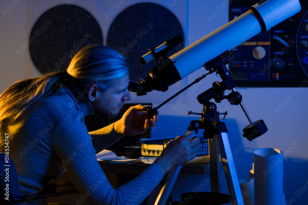 Astronomer man looks through telescope at the night sky, space, cosmos ...