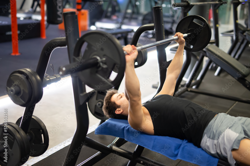 Bodybuilder lifting a weight on the flat bench Stock Photo | Adobe Stock