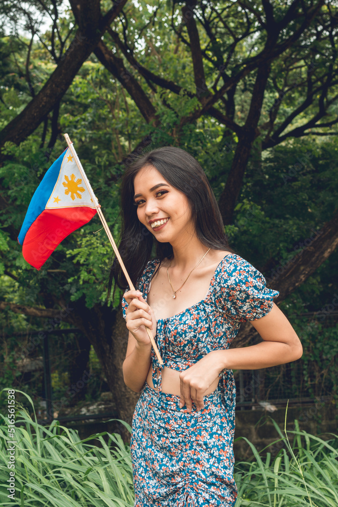 A cute and patriotic teenage lady proudly holding the Philippine Flag ...