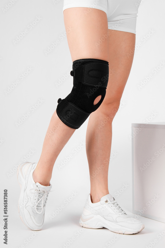 Knee Support Brace on leg isolated on white background. Elastic orthopedic orthosis. Anatomic ...